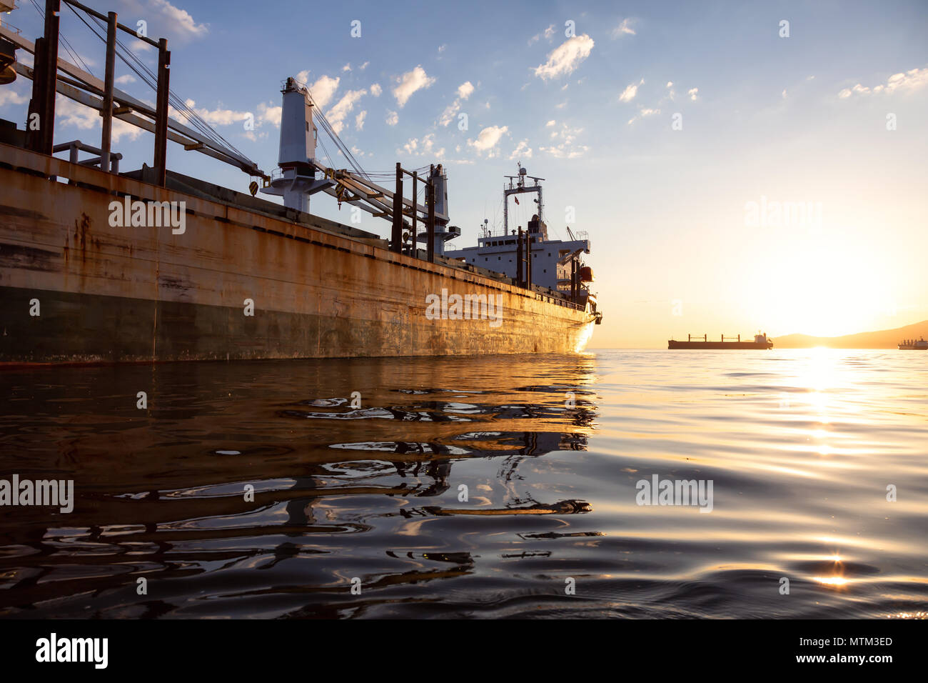 Old rusty ship is parked in the Port during a vibrant sunset. Taken in ...