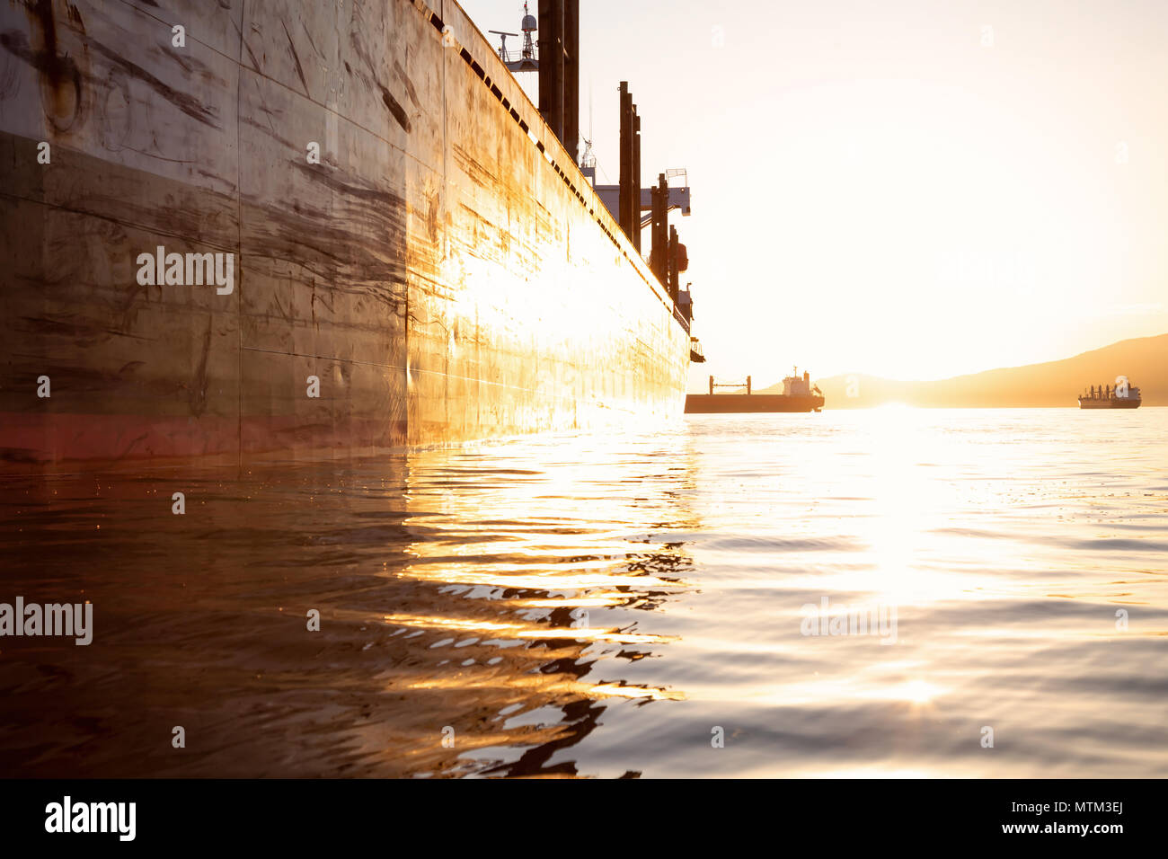 Old rusty ship is parked in the Port during a vibrant sunset. Taken in ...