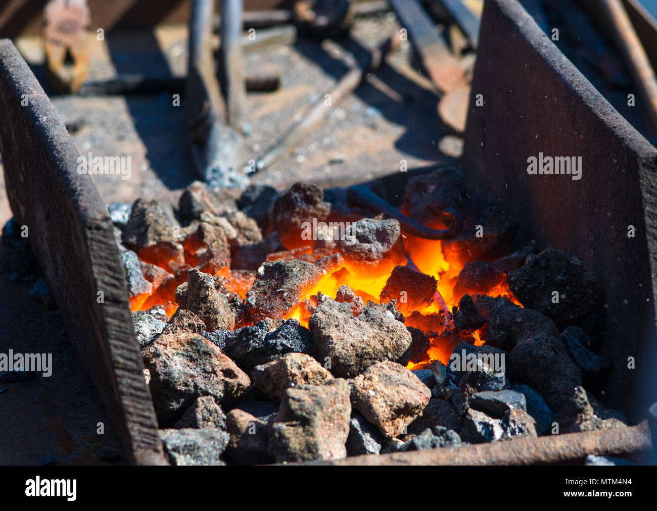 blacksmith furnace with burning coals, tools, and glowing hot metal ...