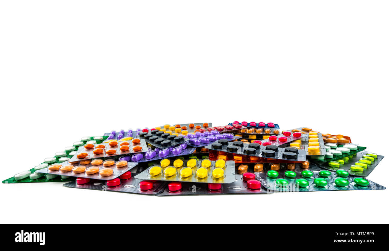 Pile of tablet pills isolated on white background. Yellow, purple ...