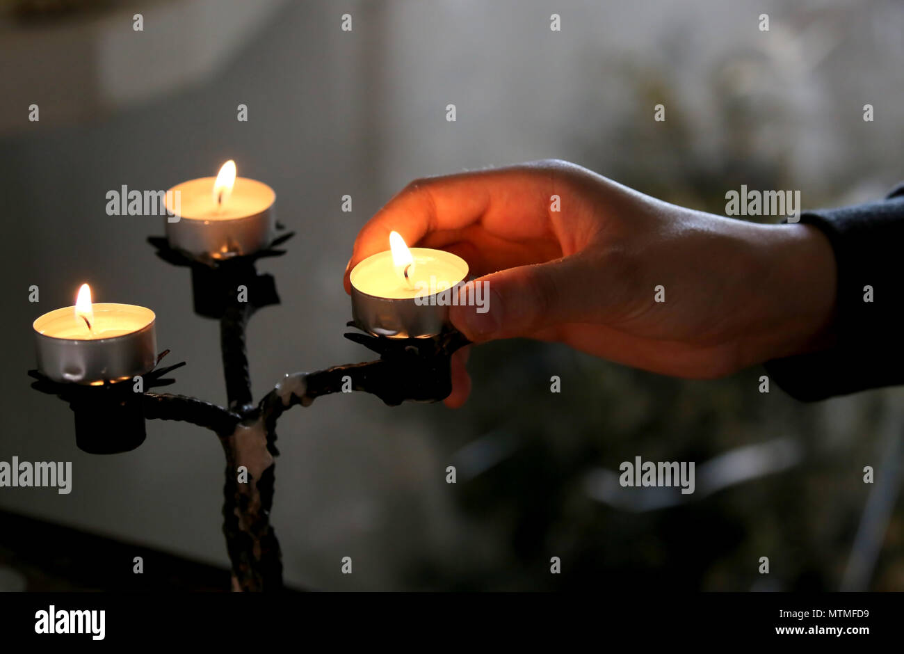 three candles in the church and an hand of a young boy Stock Photo - Alamy