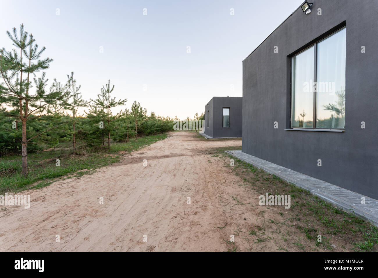 Side view of an open veranda in front of a modern forest cottage. Pine ...
