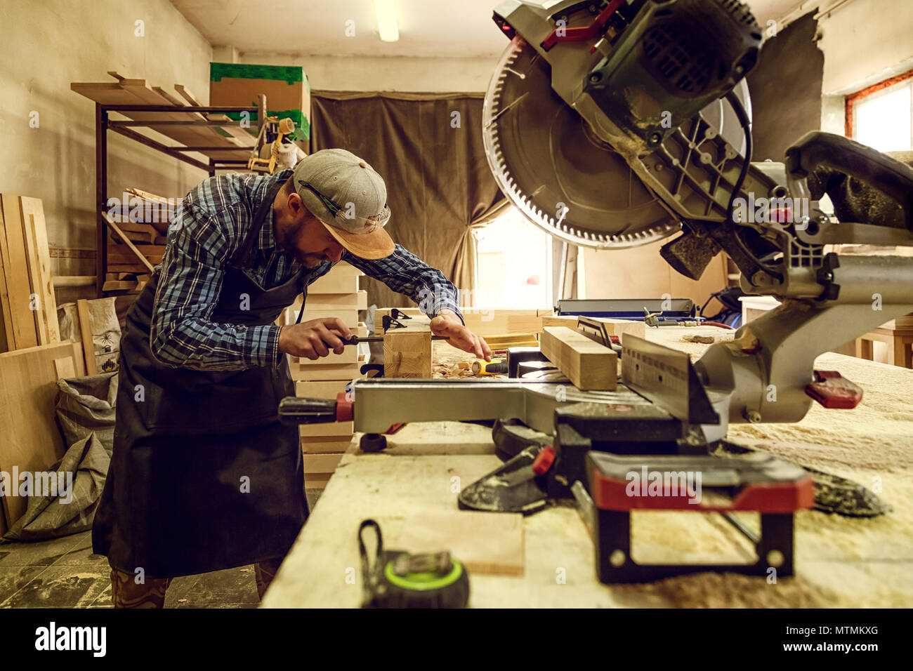 experienced carpenter in work clothes and small buiness owner working ...