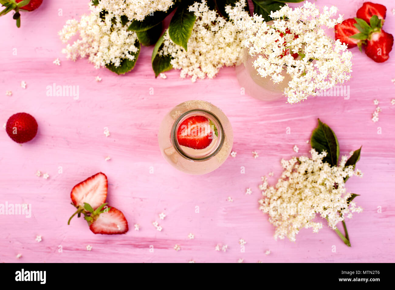 Kombucha tea with elderflower flower and strawberry on pink background ...
