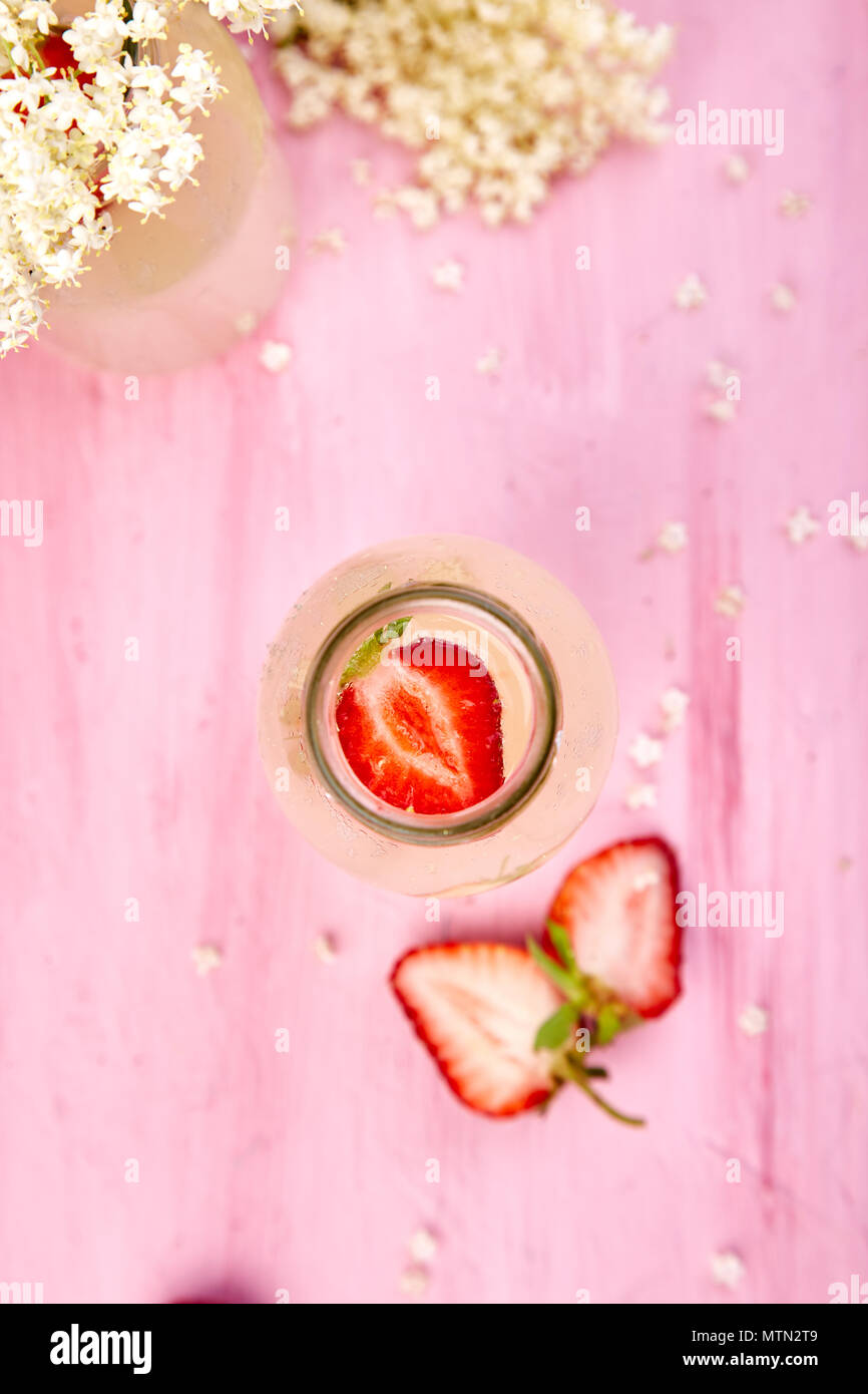 Kombucha tea with elderflower flower and strawberry on pink background ...