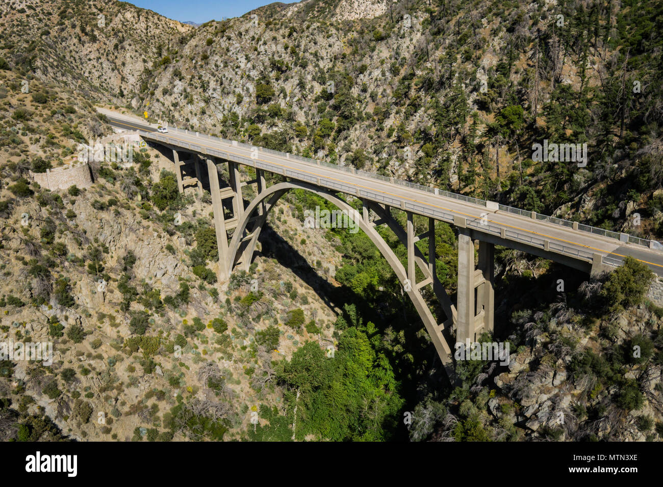 Long span of an arch bridge above a wooded valley in the Angeles ...