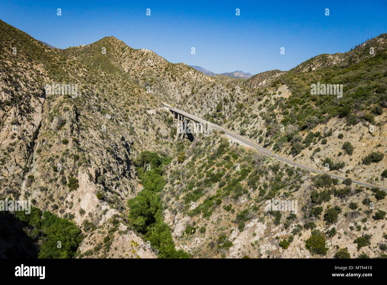 Arch bridge in the Angeles National Forest crosses a rocky canyon gorge ...