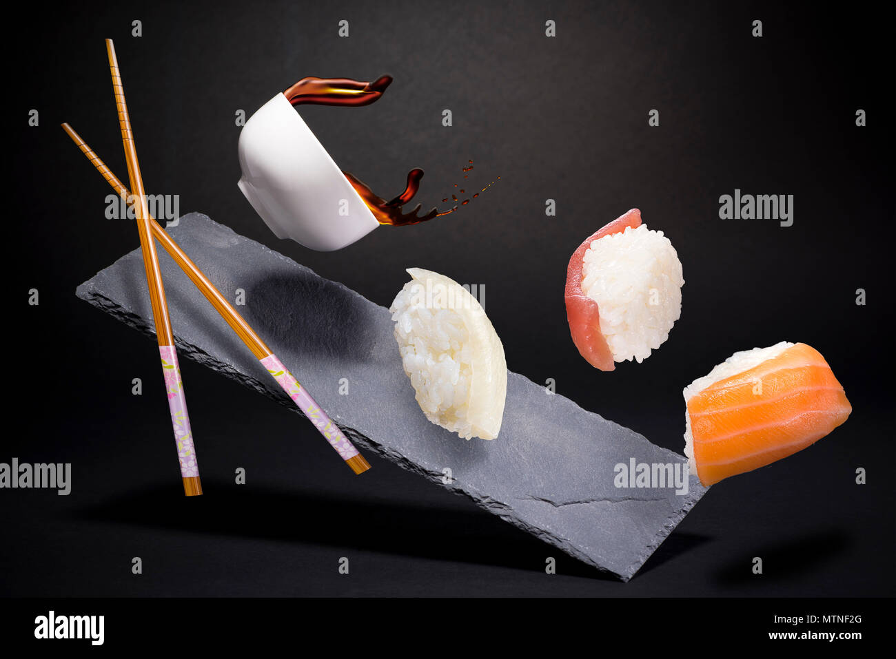 flying sushi, nigiri and soy sauce over gray slate Stock Photo - Alamy