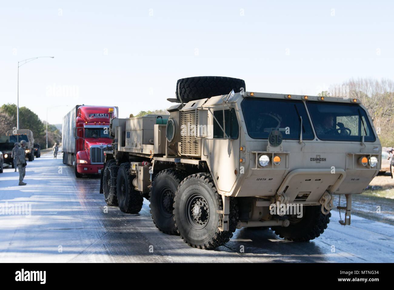 An Alabama National Guard wrecker pulls an 18-wheeler across a frozen ...