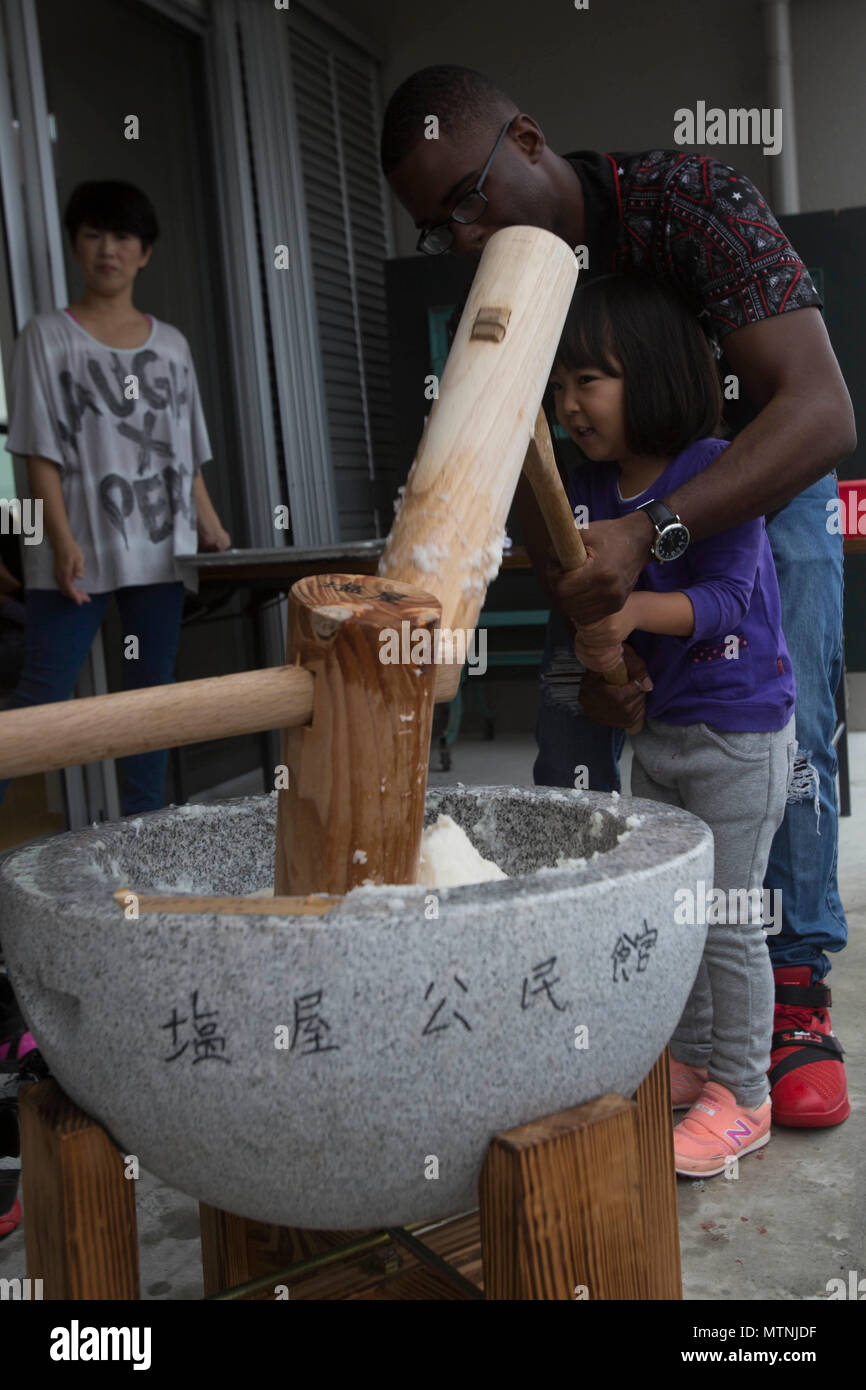 Cpl. Daniel L. Jean-Paul assists a child with a mallet while pounding ...
