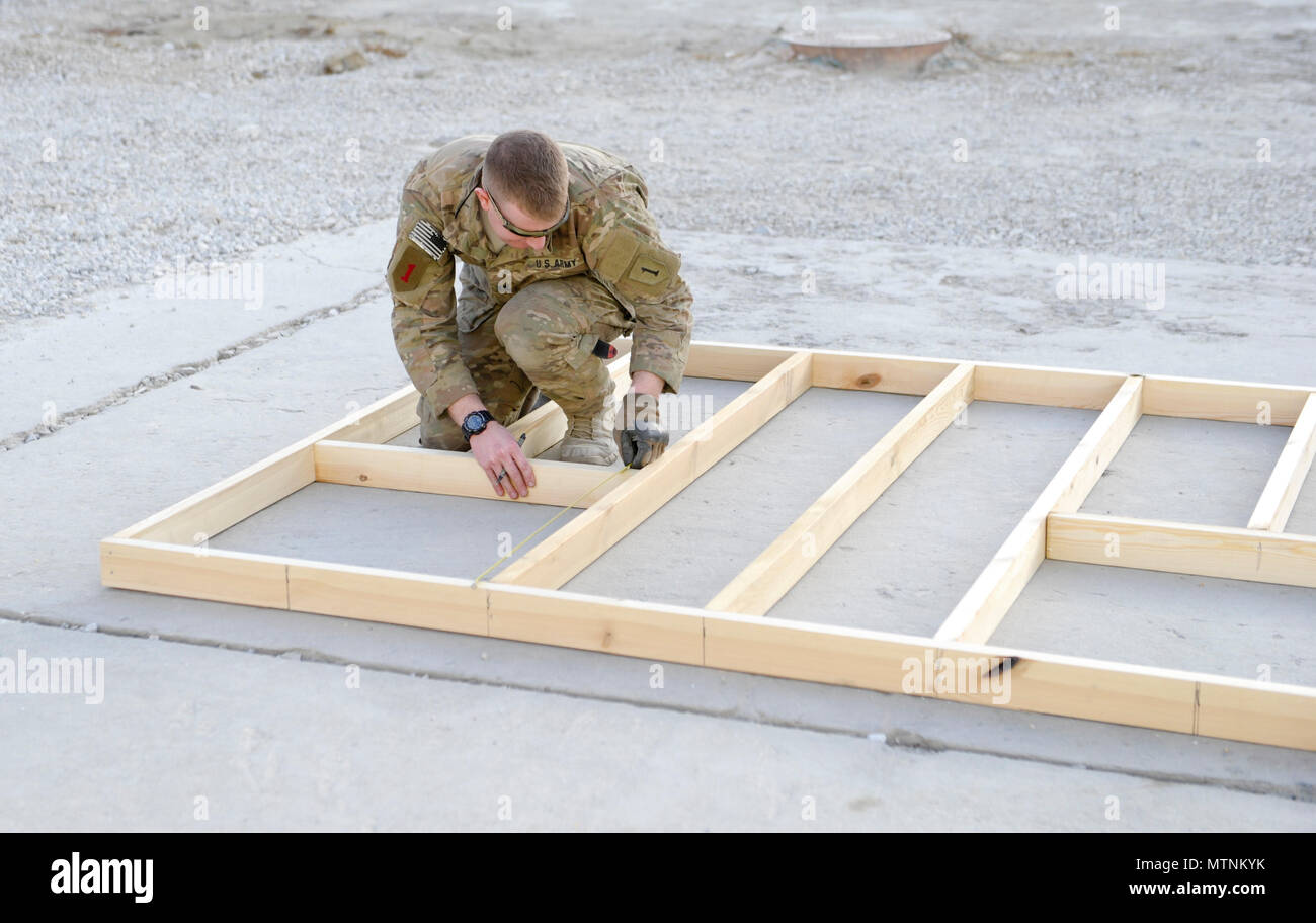 U.S. Army Capt. Grant Cuprak measures a frame that is part of a modular ...