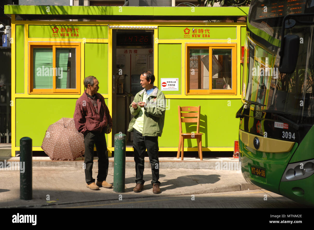 Men waiting outside bus terminal, Macau Stock Photo - Alamy