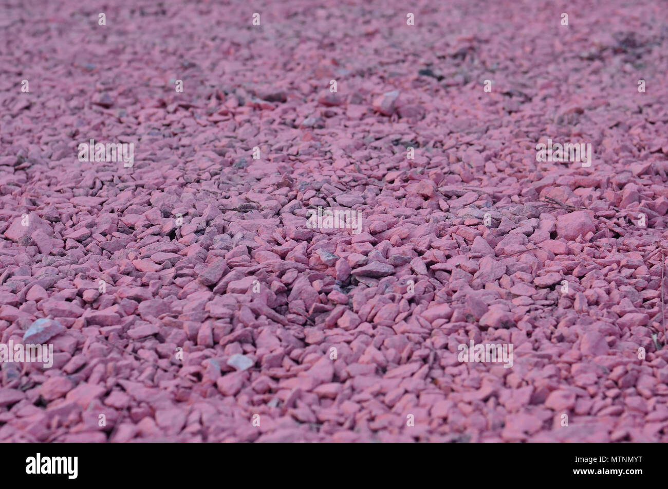 Texture from a pile of crushed stone, painted in light pink color ...