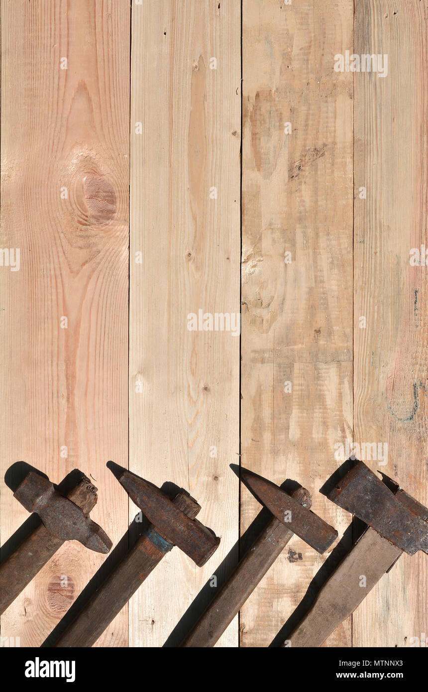 A few rusty hammers on a wooden background. Obsolete household tools ...