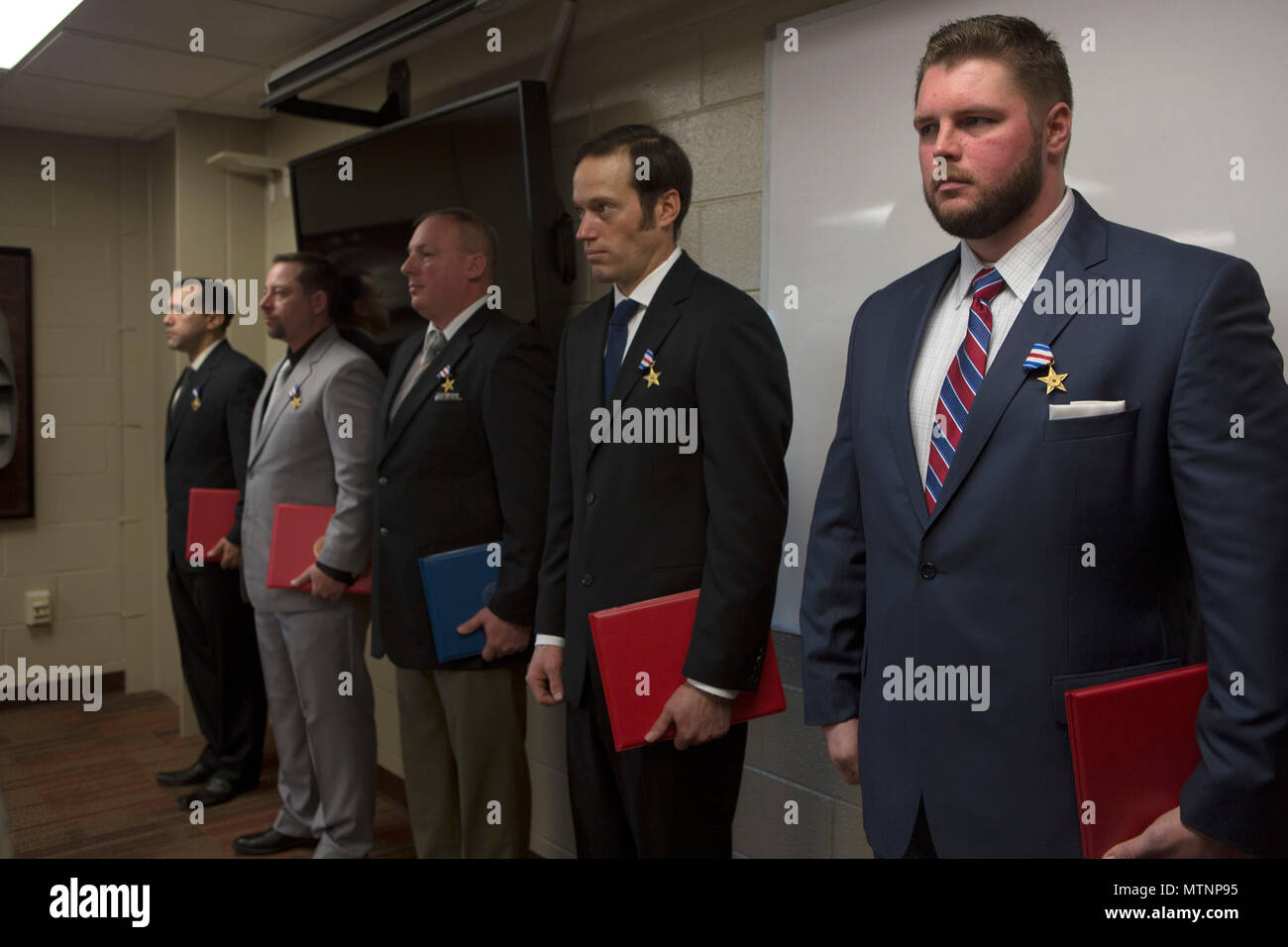 Four prior service Marines and one Sailor stand after receiving awards ...