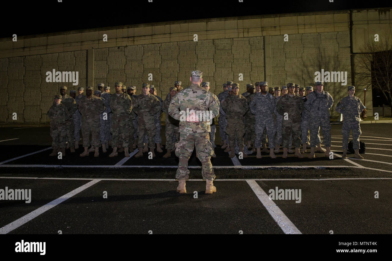 U.S. Soldiers stand in formation waiting to board a bus to an assembly ...