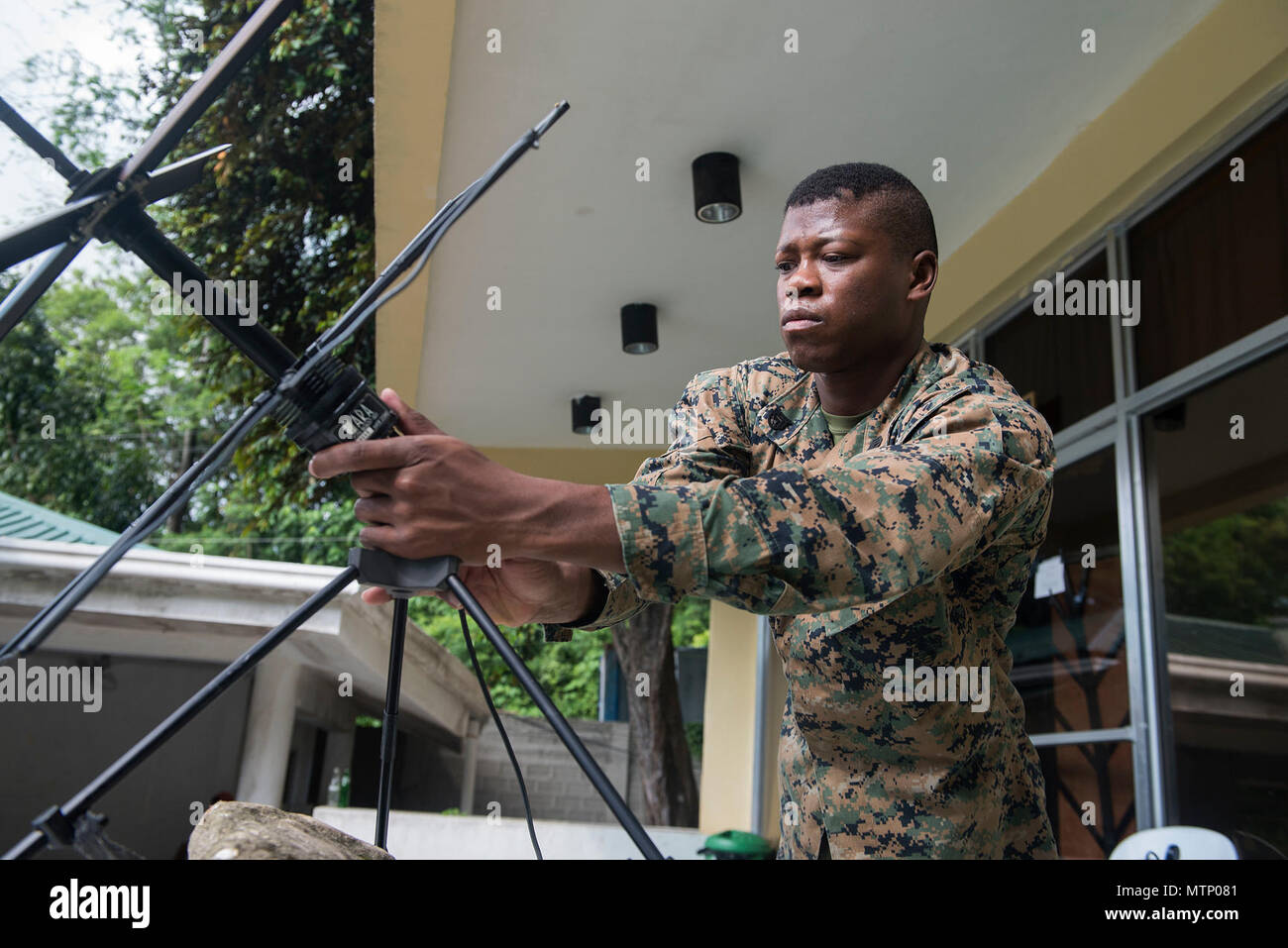 U.S. Marine Staff Sgt. Alexander Davis adjusts a satellite ...