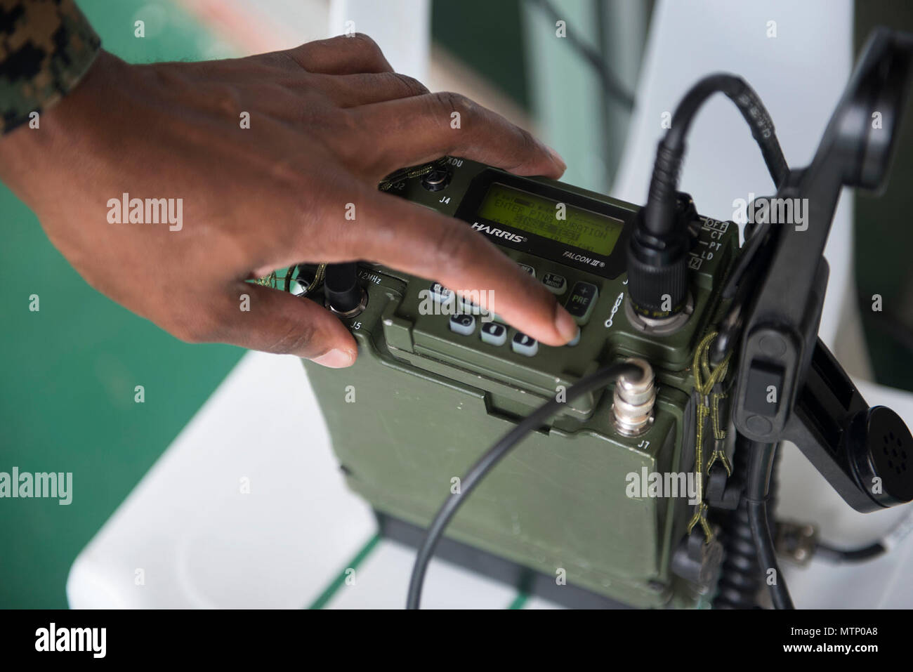 U.S. Marine Staff Sgt. Alexander Davis adjusts a AN/PRC-117G radio ...