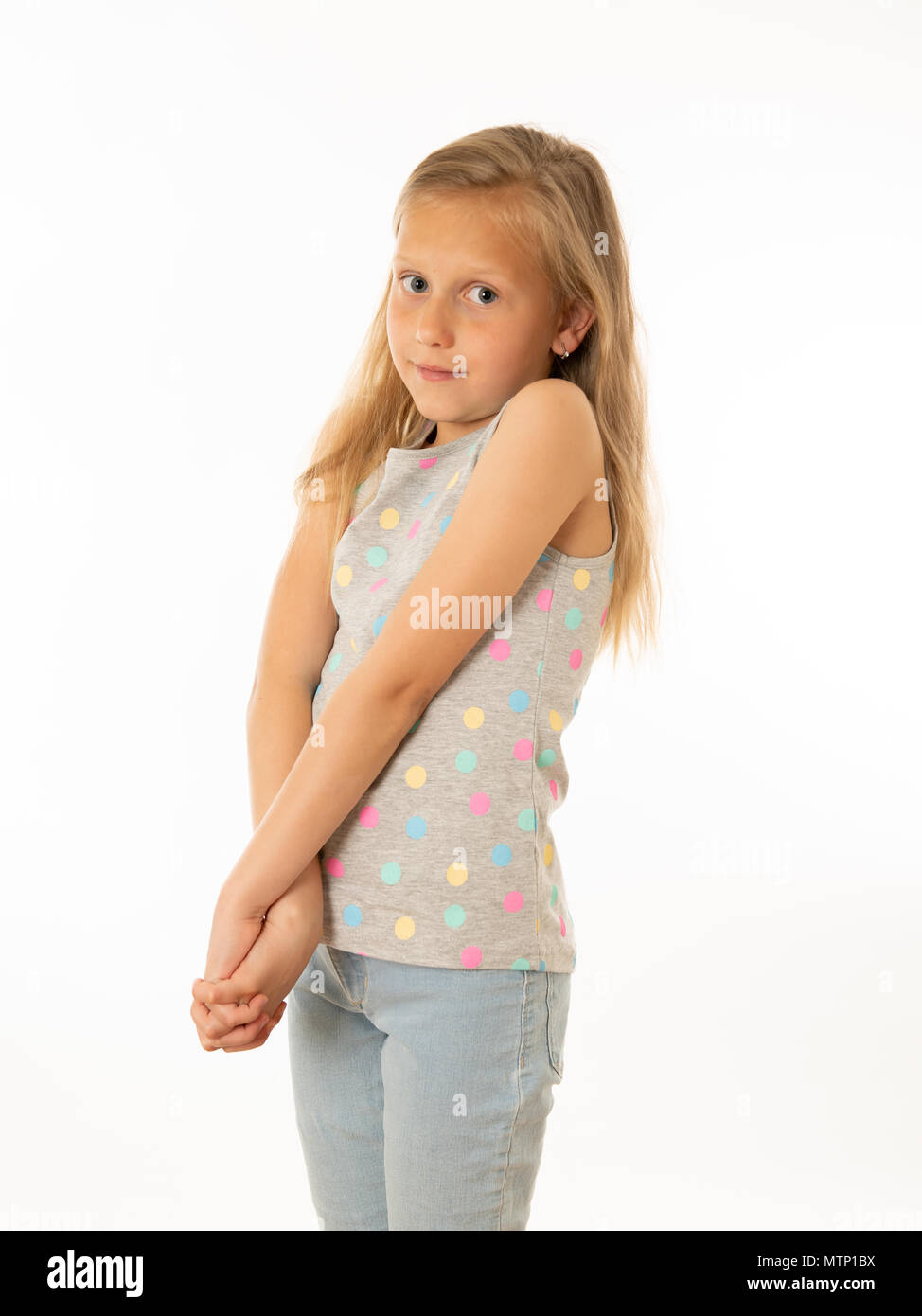 Close up portrait of a cute young shy girl looking timid at the camera ...