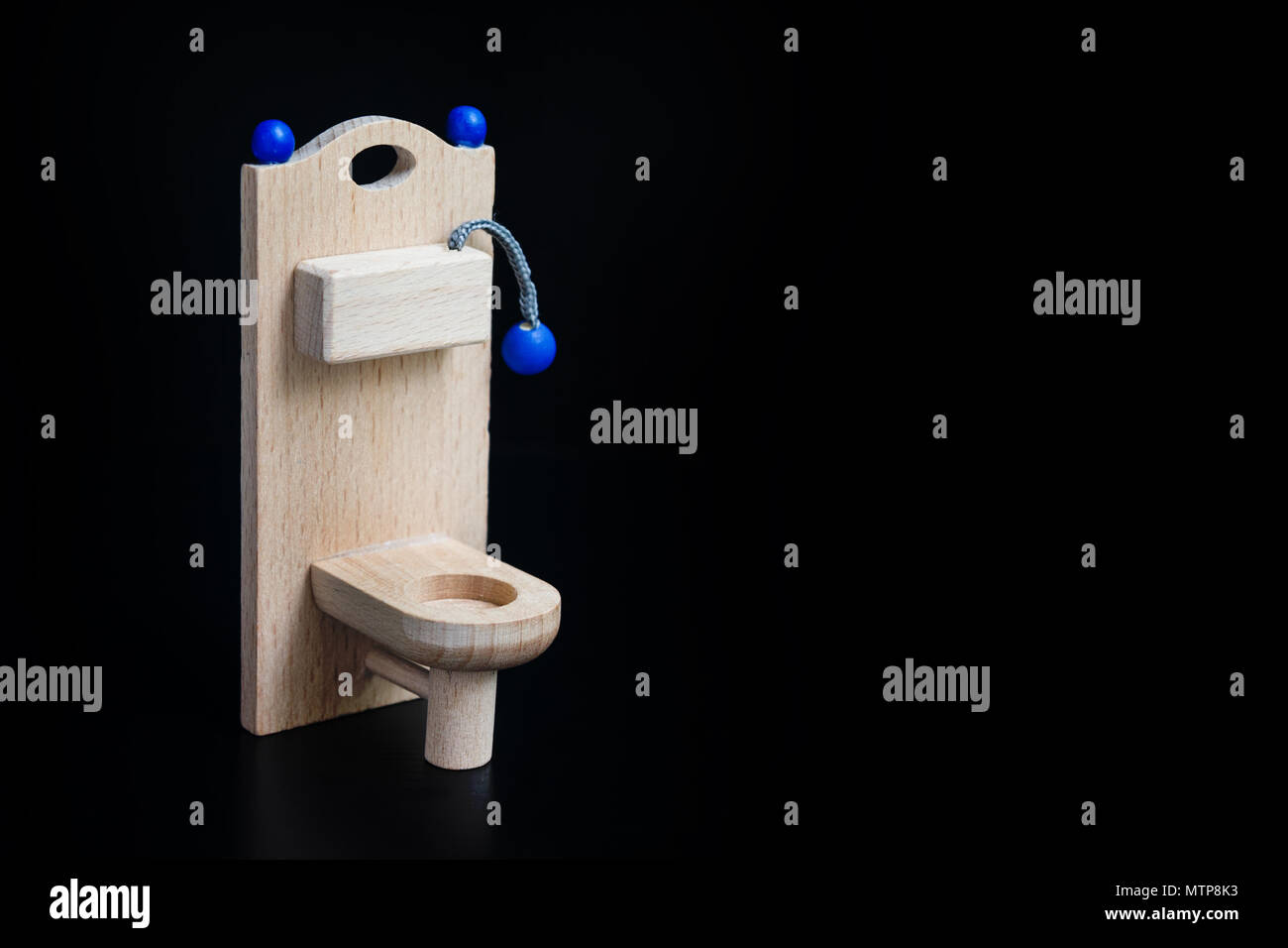 Wooden toy toilet on black background Stock Photo - Alamy