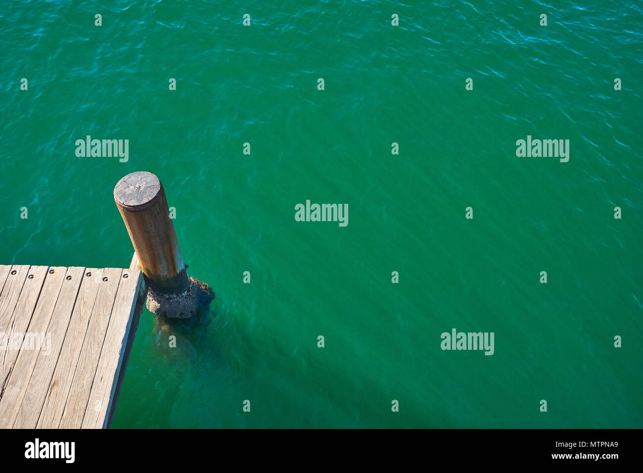 The end of a wooden jetty and its support post in the corner of an ...