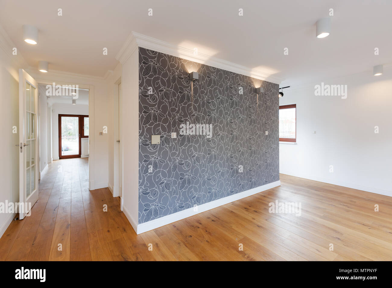 Spacious corridor in modern villa with wood flooring and light walls ...