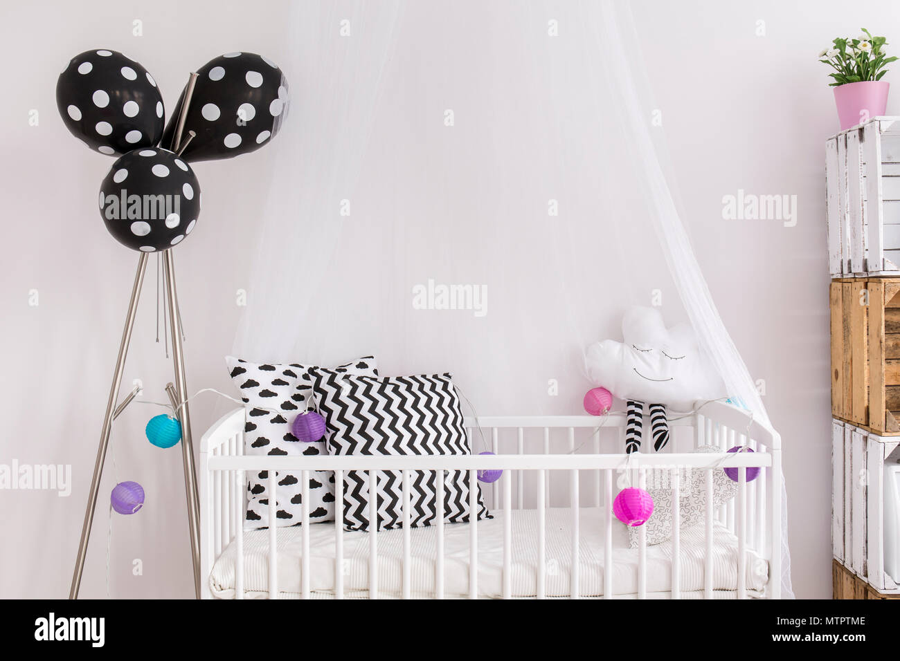 White cradle with canopy and black and white pillows in little baby's ...