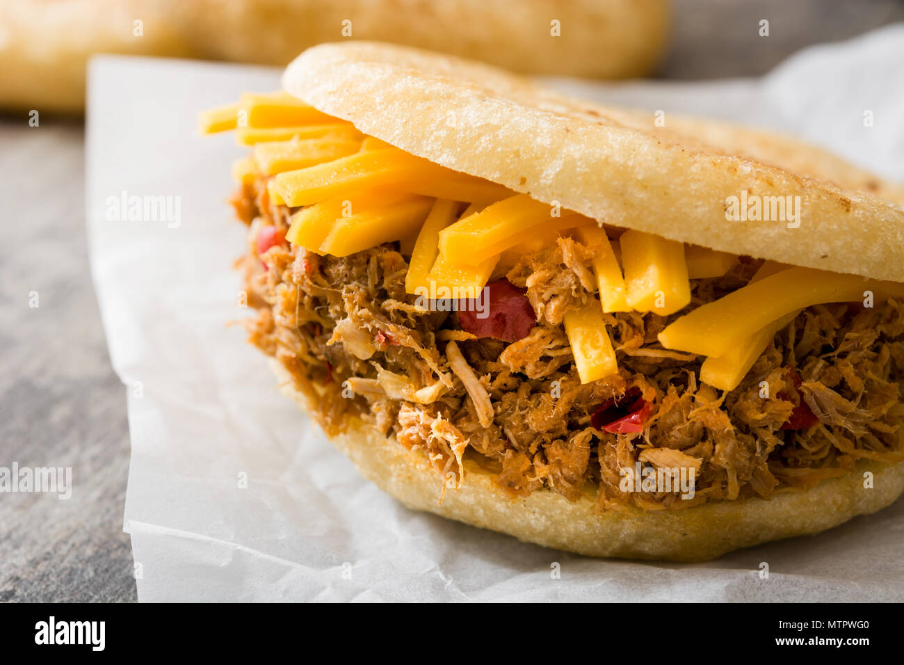 Arepa with shredded beef and cheese on wooden background. Venezuelan ...
