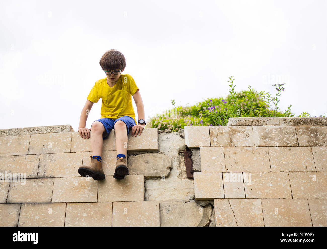 Young boy of ten sites on a wall. Humpty Dumpty sat on a wall, Humpty ...