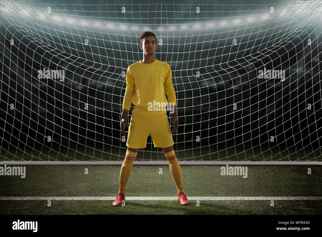 Goalkeeper standing in front of goal Stock Photo - Alamy