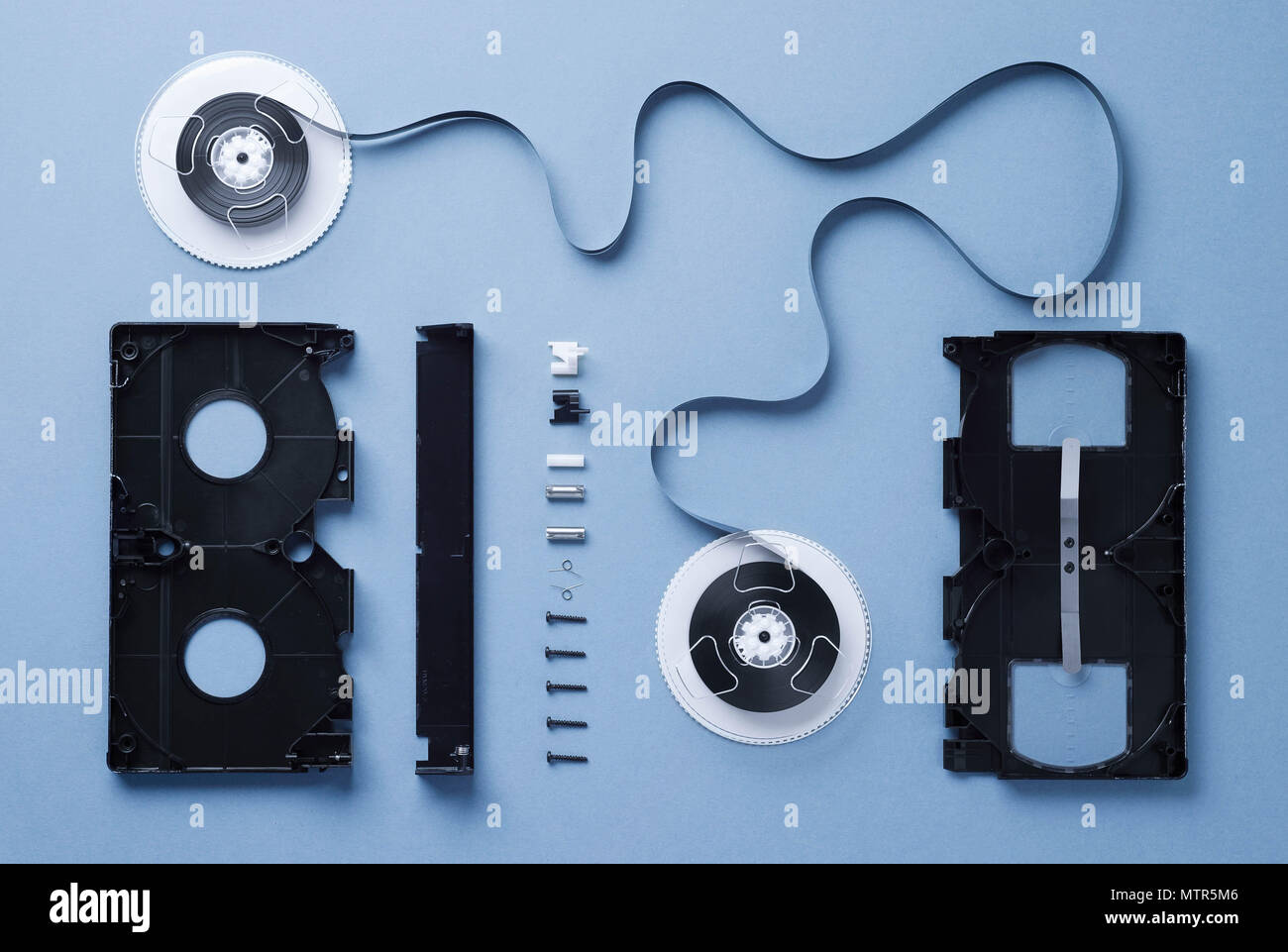 Components of a VHS Cassette disassembled and well arranged over blue ...