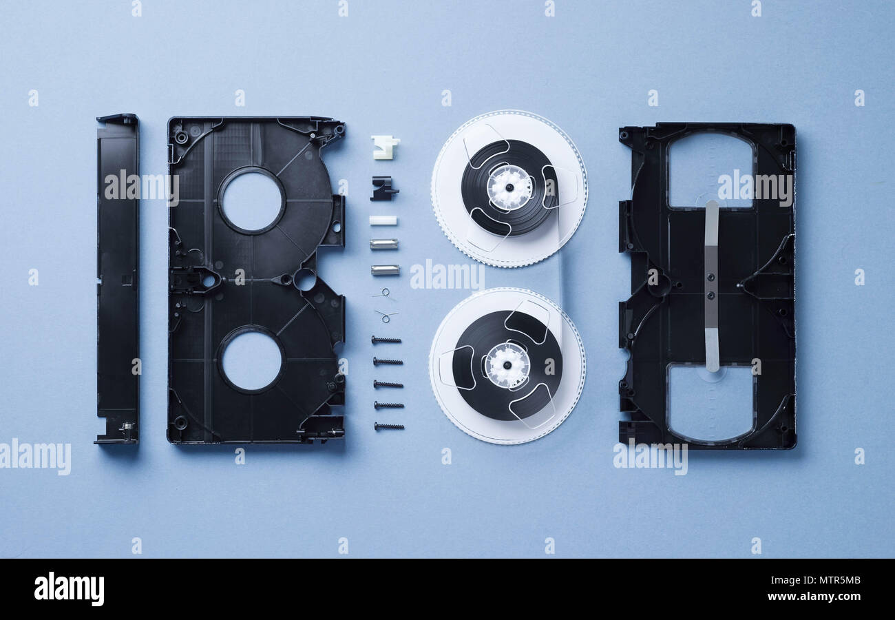 Components of a VHS Cassette disassembled and well arranged over blue ...
