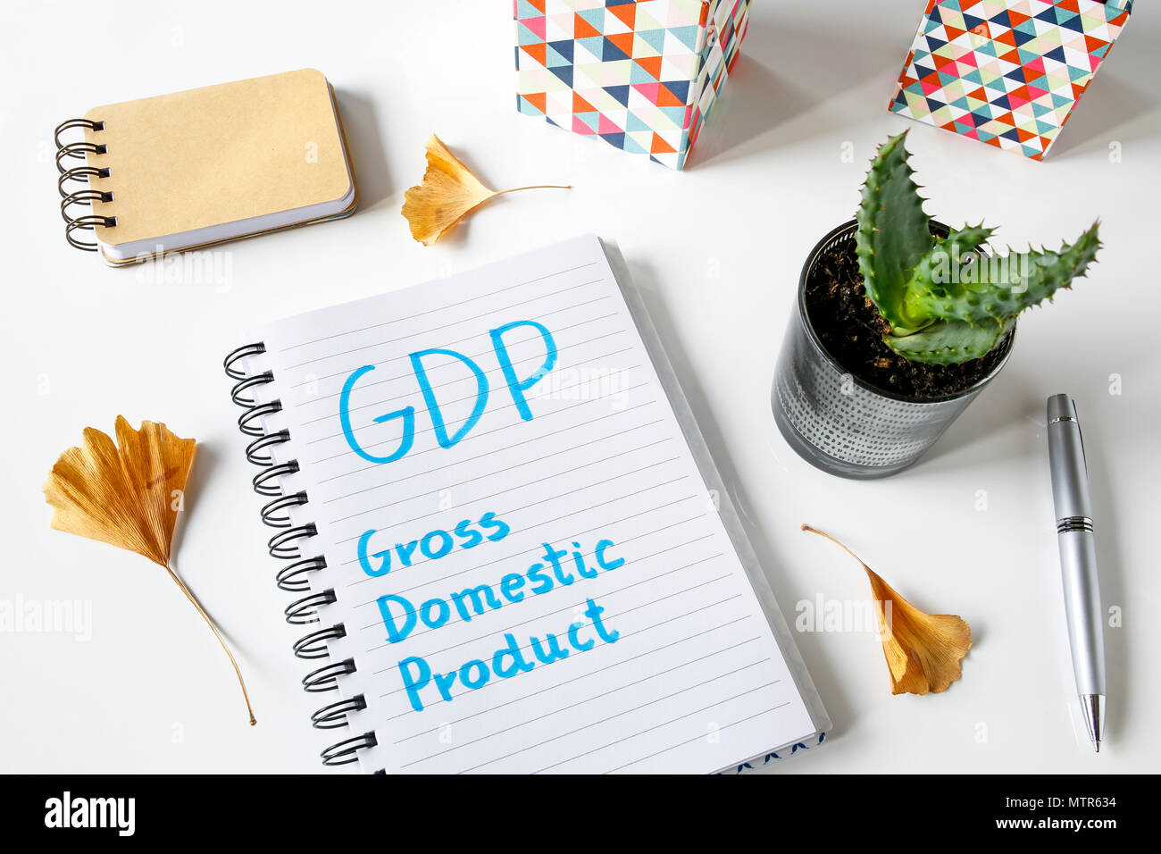 GDP (Gross Domestic Product) acronym written in notebook on white table ...