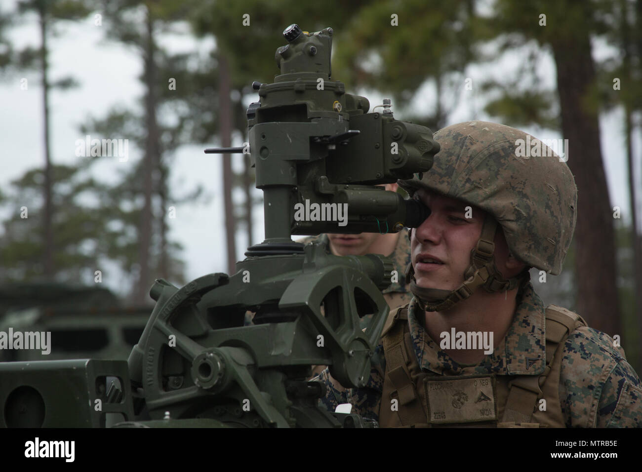 Lance Cpl. Christopher Ploof aims down the sight of an M777A2 towed ...