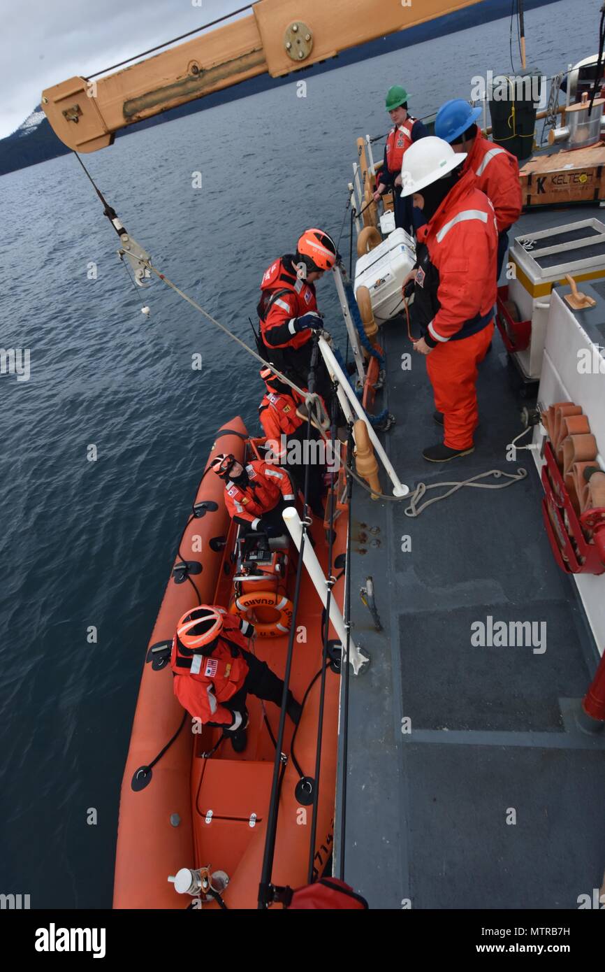 Crewmembers aboard the Coast Guard Cutter Anacapa lower their smallboat ...