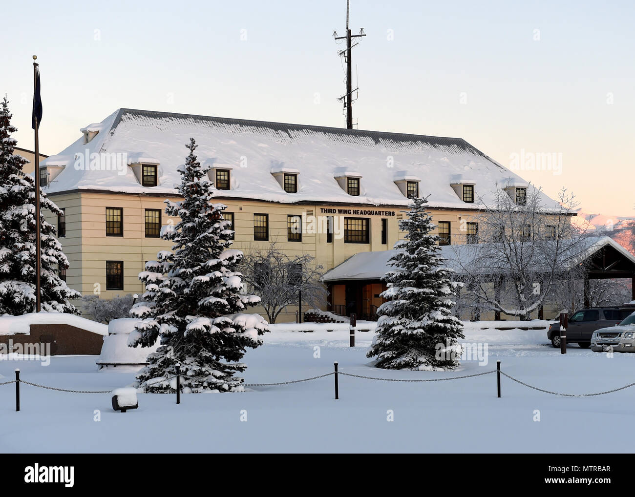 Purple light from an Alaska sunset shines on the 3rd Wing Headquarters ...