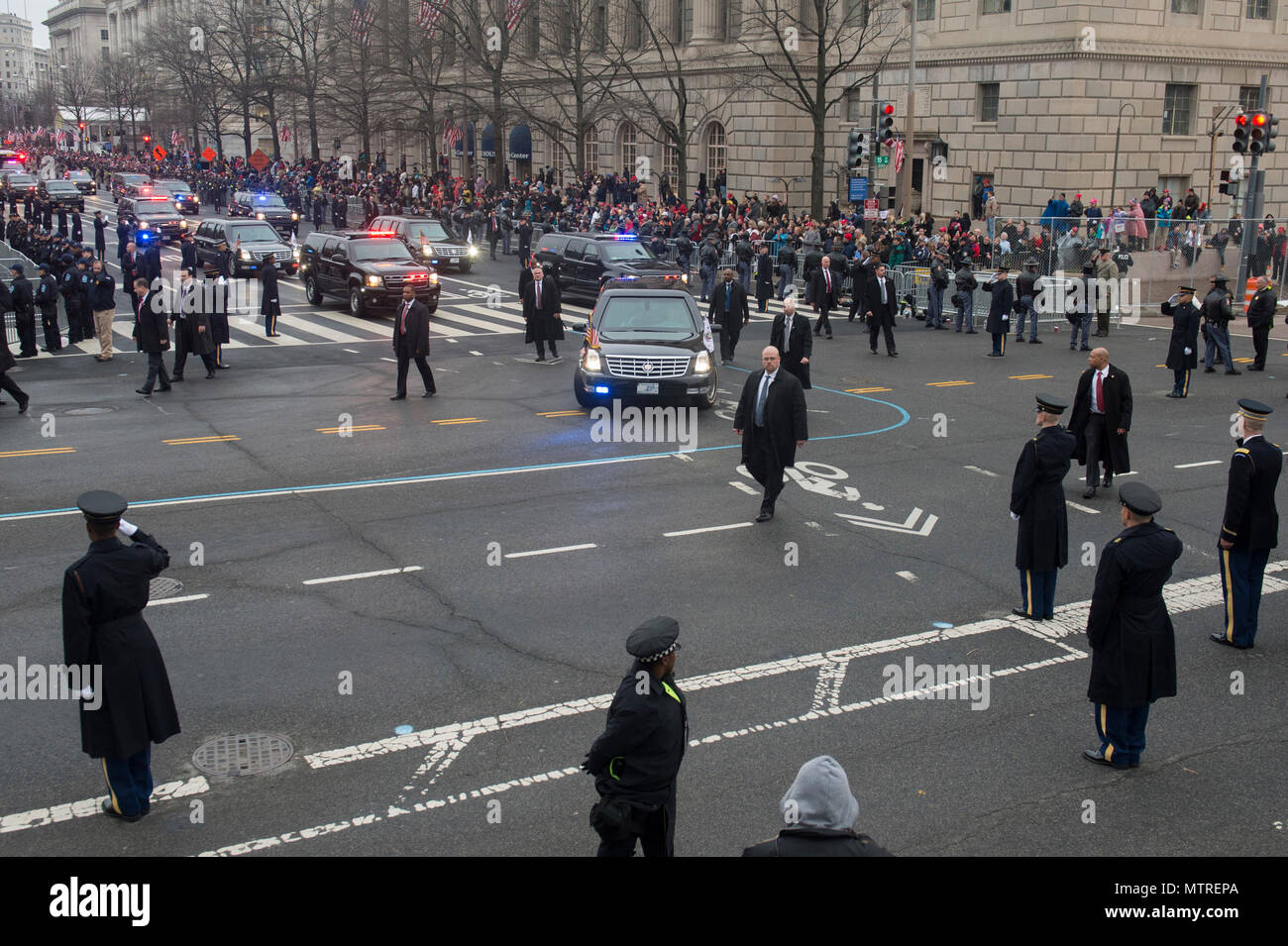 U.S. Secret Service members escort the vice-presidential limousine ...