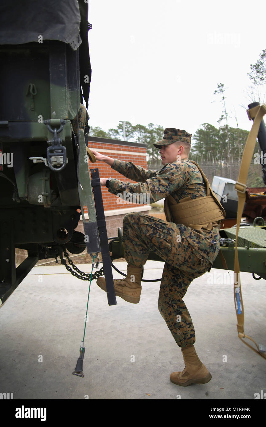 A Marine climbs into a tactical vehicle during a Strategic Mobility ...