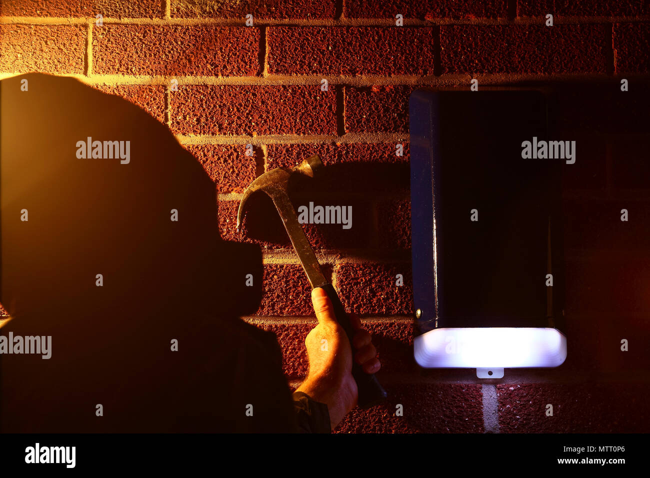 Conceptual image of a burglar trying to disarm a residential security ...