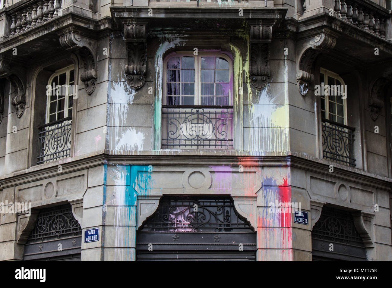 Facade of aged polluted building with red, green, yellow, purple and ...
