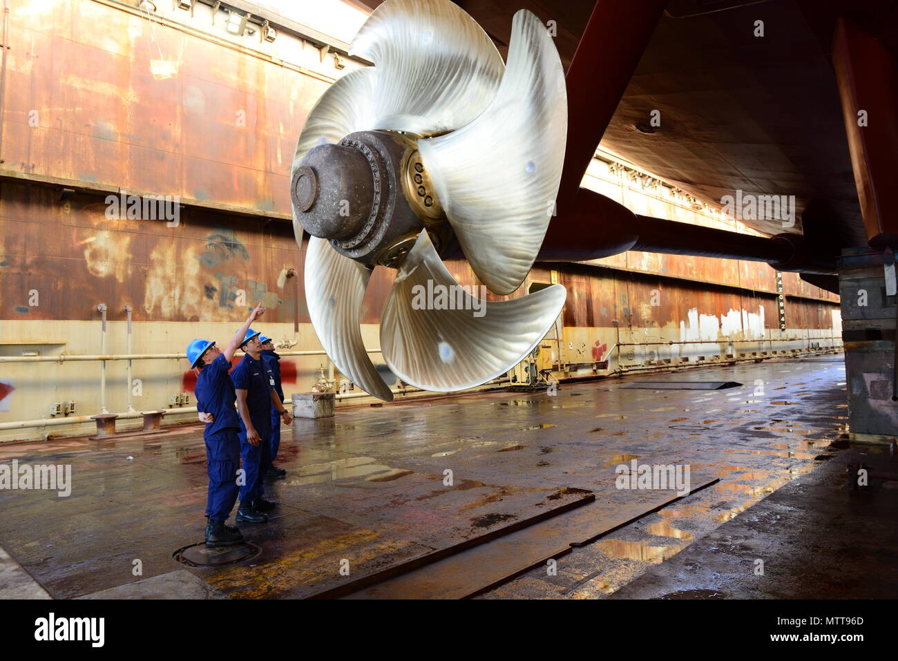 Crewmembers of the Coast Guard Cutter Waesche examine a propellor ...