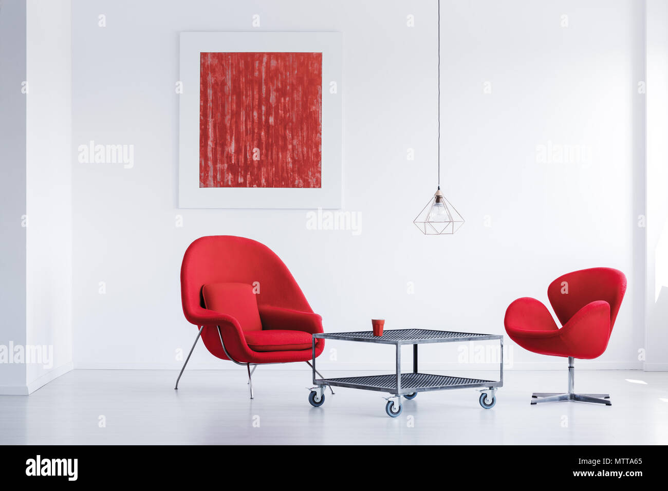 White simple waiting room with two red chairs by the industrial table ...