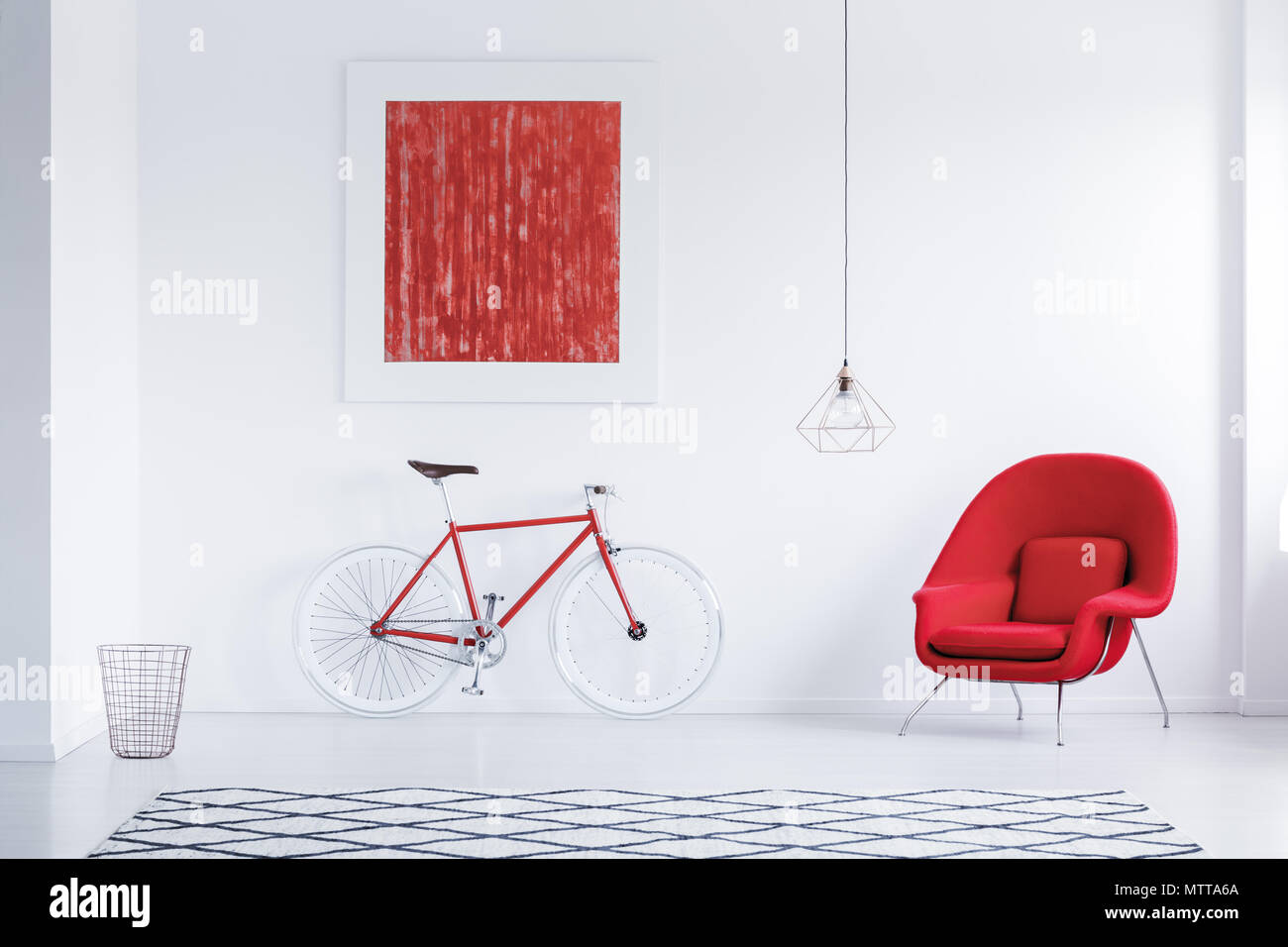Red cycle in white room with carpet with geometric pattern, armchair ...