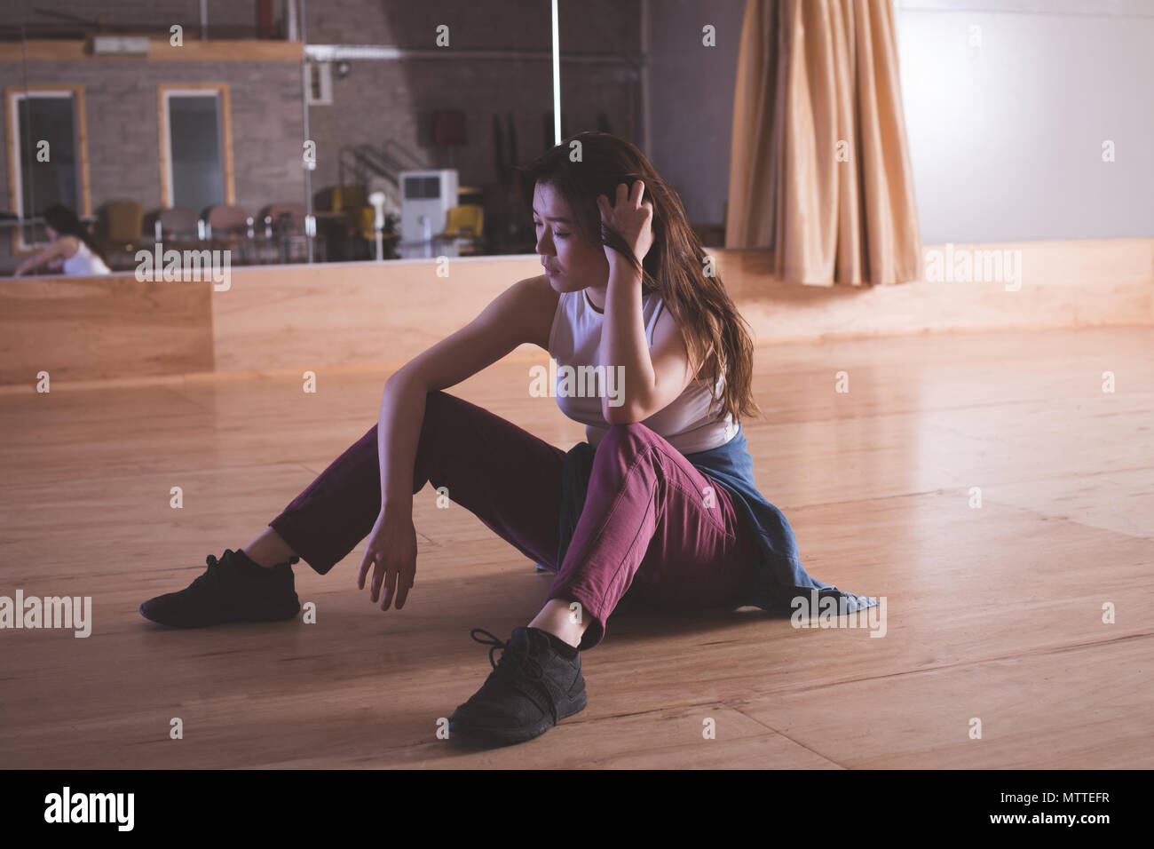 Female dancer relaxing in dance studio Stock Photo - Alamy