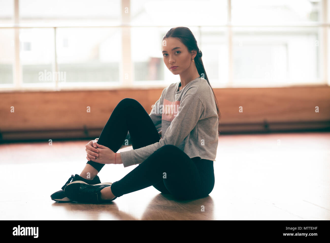 Female dancer relaxing in dance studio Stock Photo - Alamy