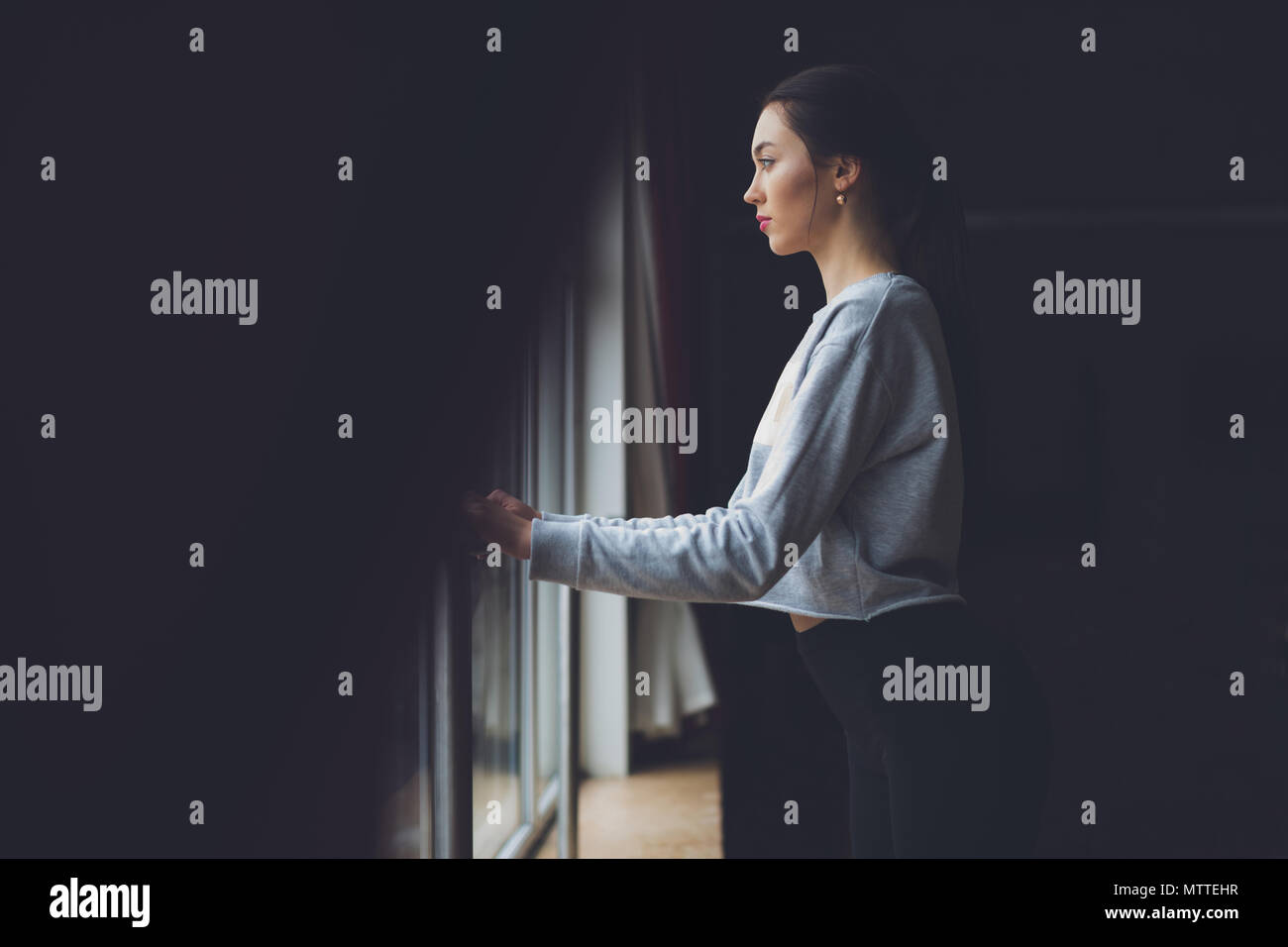Female dancer looking through window in dance studio Stock Photo - Alamy