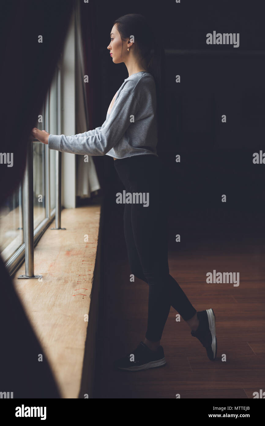 Female dancer looking through window in dance studio Stock Photo - Alamy