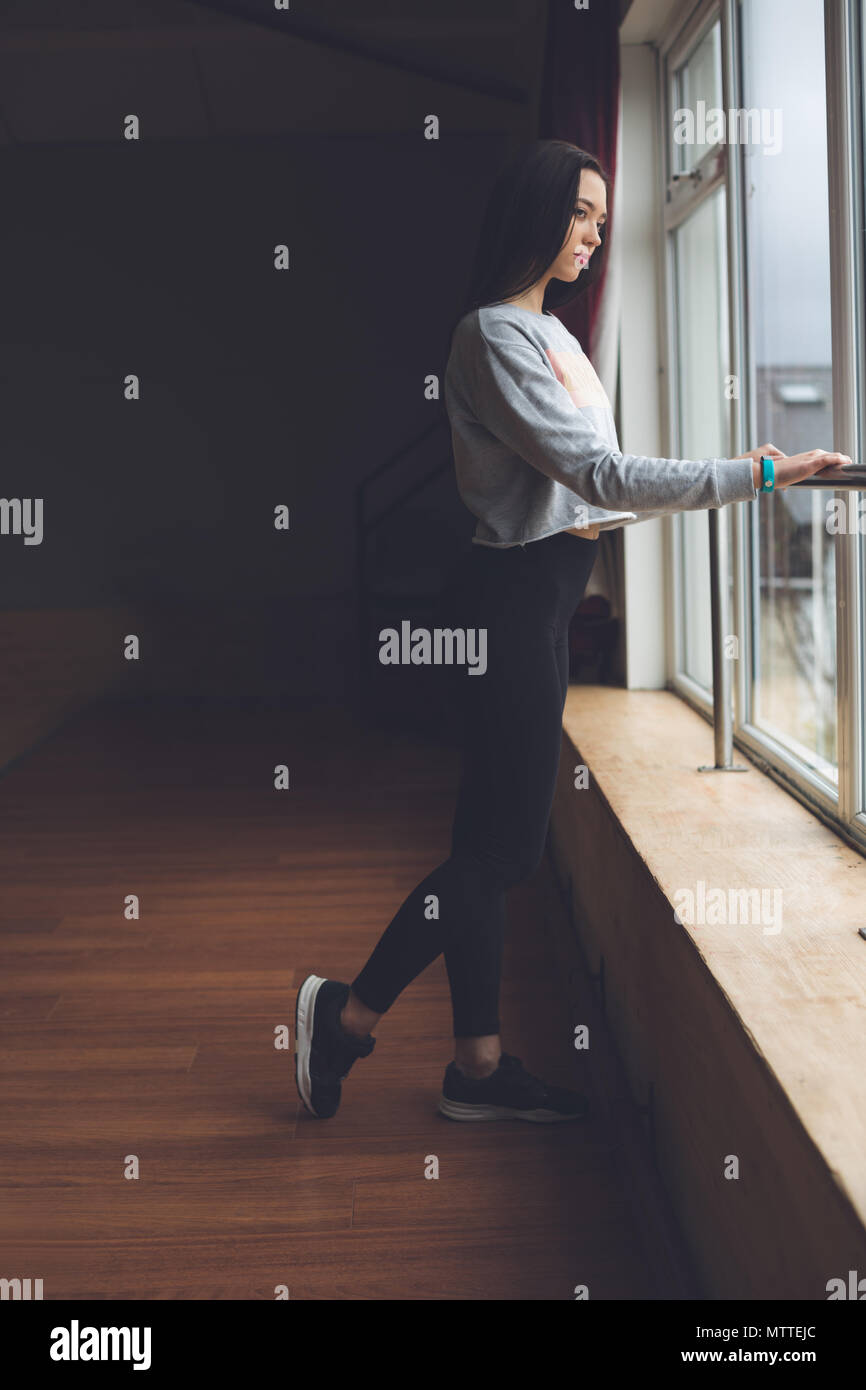 Female dancer looking through window in dance studio Stock Photo - Alamy