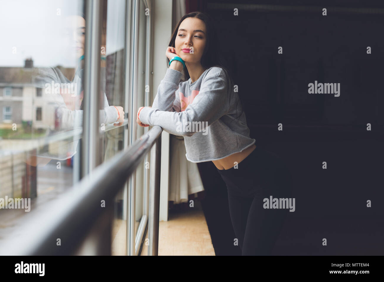 Female dancer looking through window in dance studio Stock Photo - Alamy