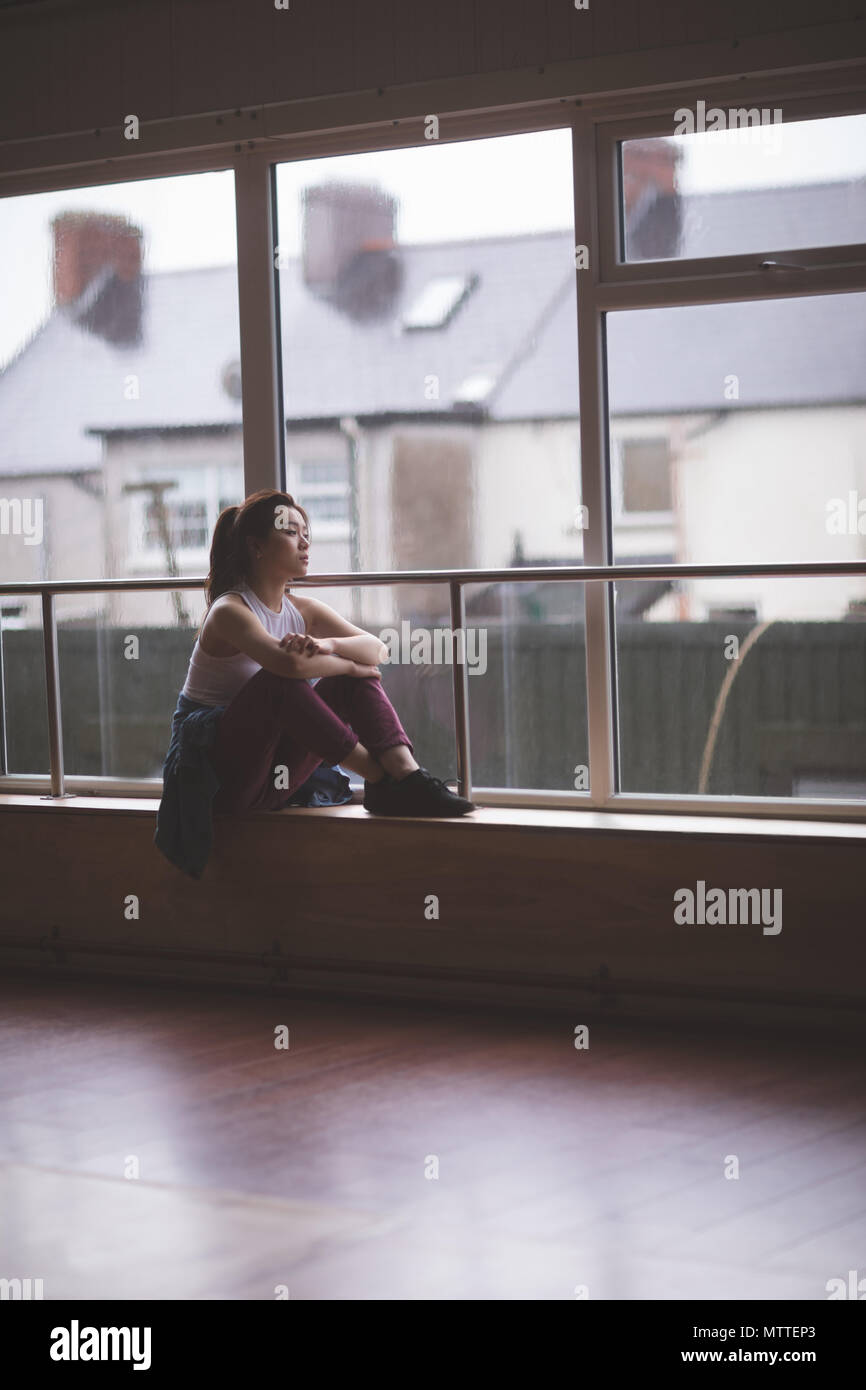Female dancer looking through window in dance studio Stock Photo - Alamy